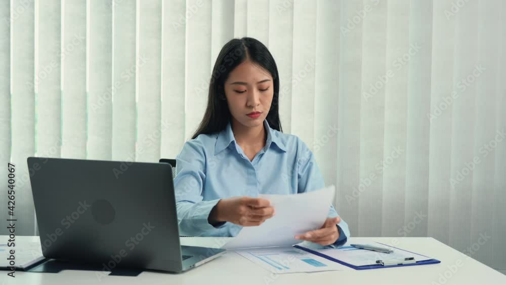 Asian woman manager is stressed and has a headache about faulty work ...