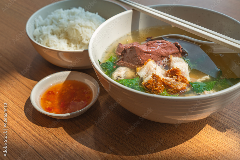 Close up Asian meal, a bowl of pig's blood soup and pork with steam ...