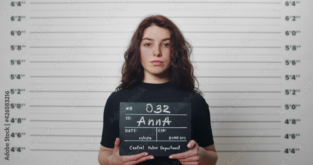Mugshot of millennial arrested woman with curly hair being photographed ...