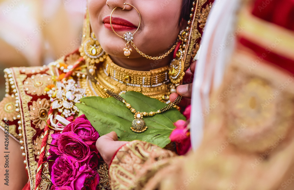 Young Indian bride wearing an ethnic traditional outfit and heavy gold ...