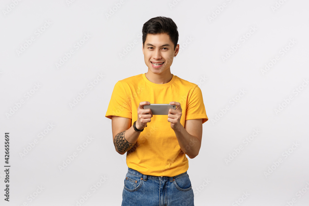 Lets play. Asian guy eager show his gaming skills, holding smartphone ...