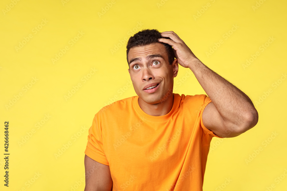 Indecisive pensive handsome silly guy in t-shirt, scratch head and look ...