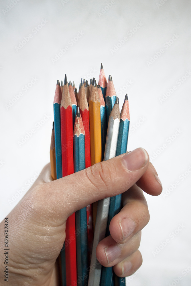 Simple gray pencils of different colors in hands isolated on white ...