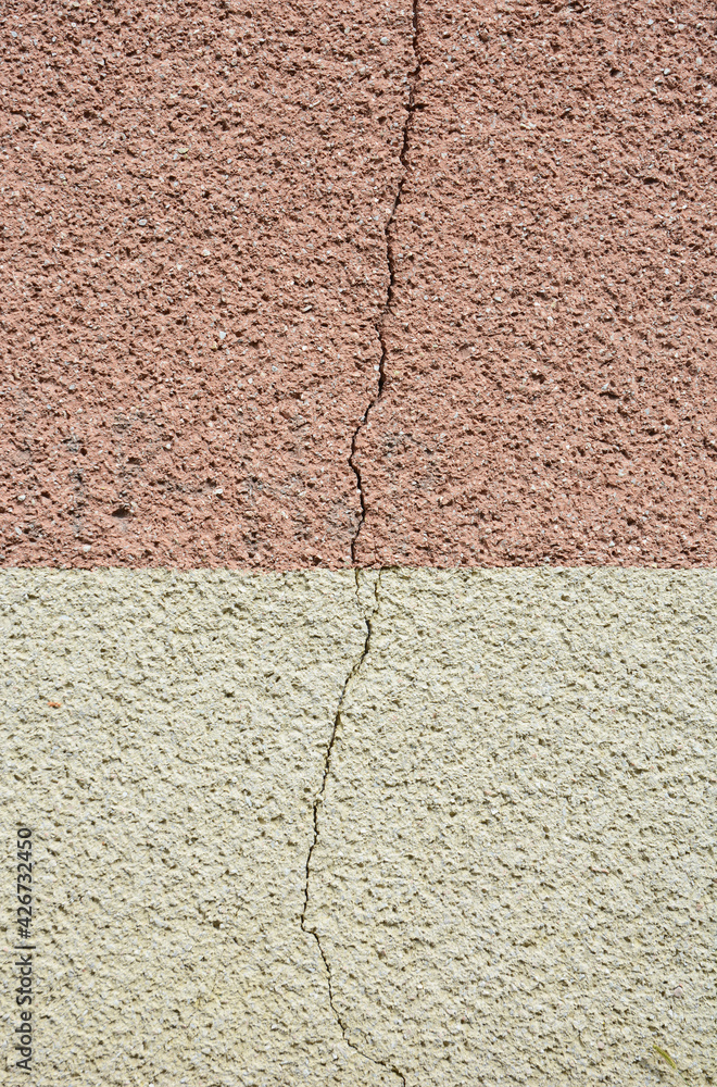 Repairing a small stucco crack on the outside house wall. Cracked ...