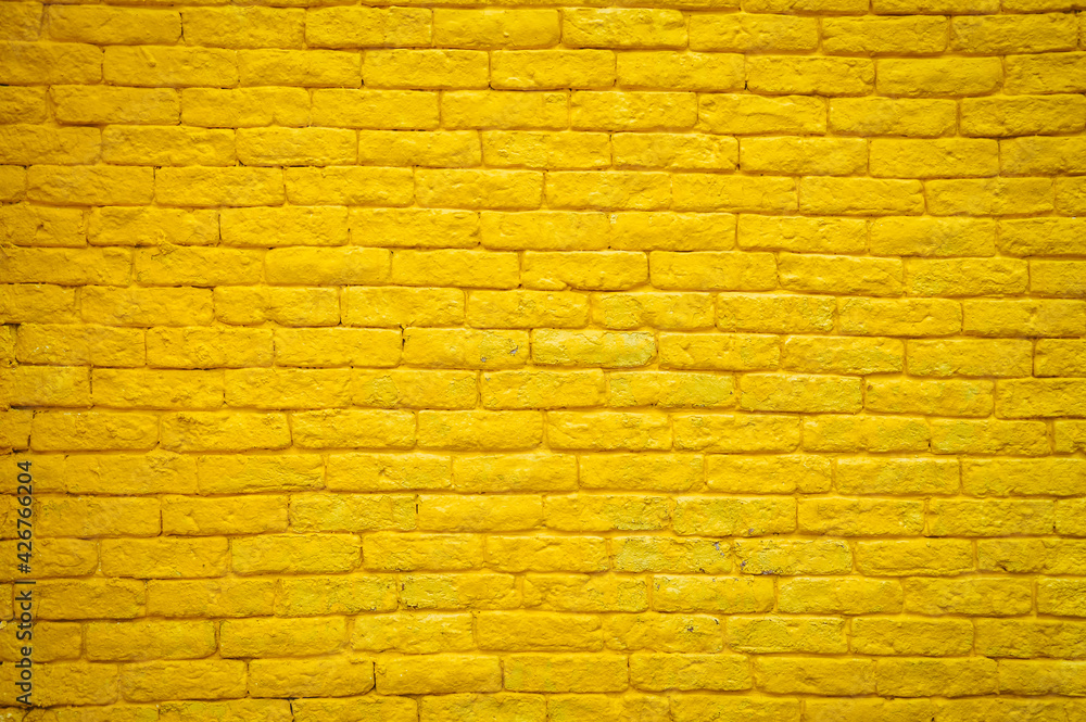Yellow abstract background. The wall is made of old yellow brick. The ...