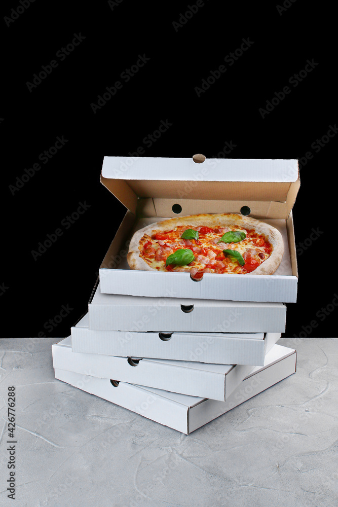 stack of pizza box with pizza inside. pizza delivery. box on black ...