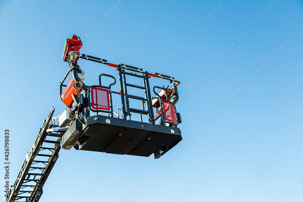 Red and yellow modern fire fighter truck equipped with extended crane ...