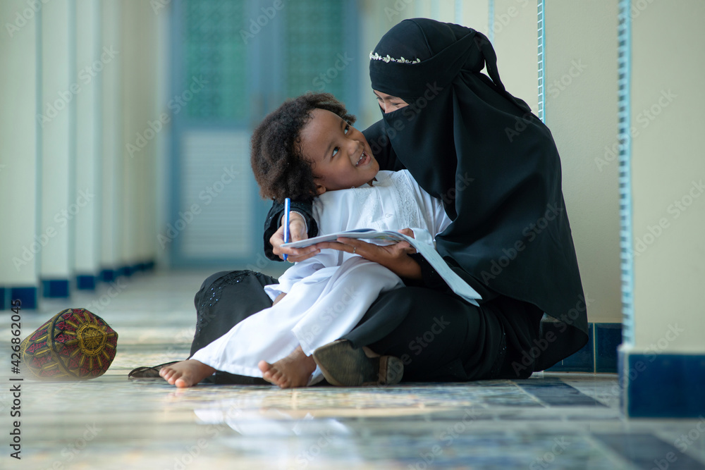 Muslim mother teaches her son to read Arabic, Looking at each other ...