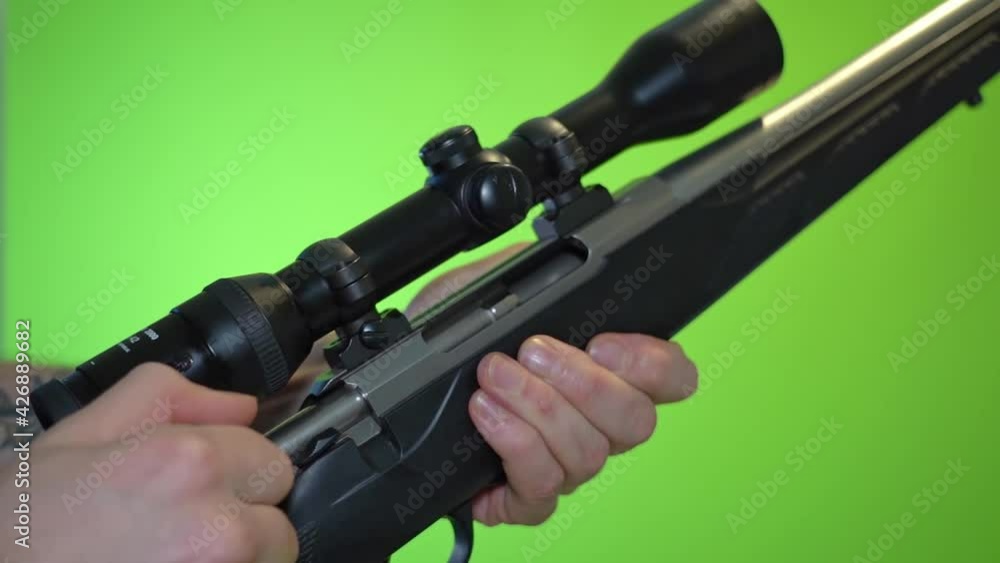 Pulling back end piece and reloading rifle by putting new cartridge ...