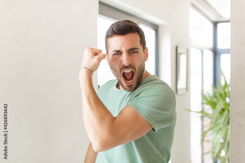 handsome man feeling happy, satisfied and powerful, flexing fit and ...