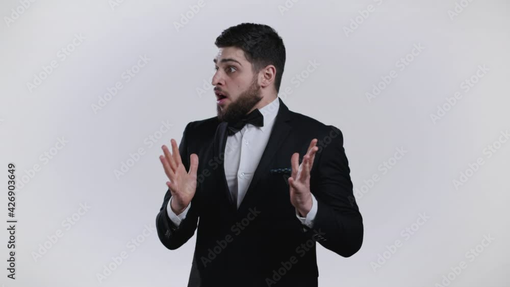 Frightened man in tuxedo afraid of something and looks into camera with ...