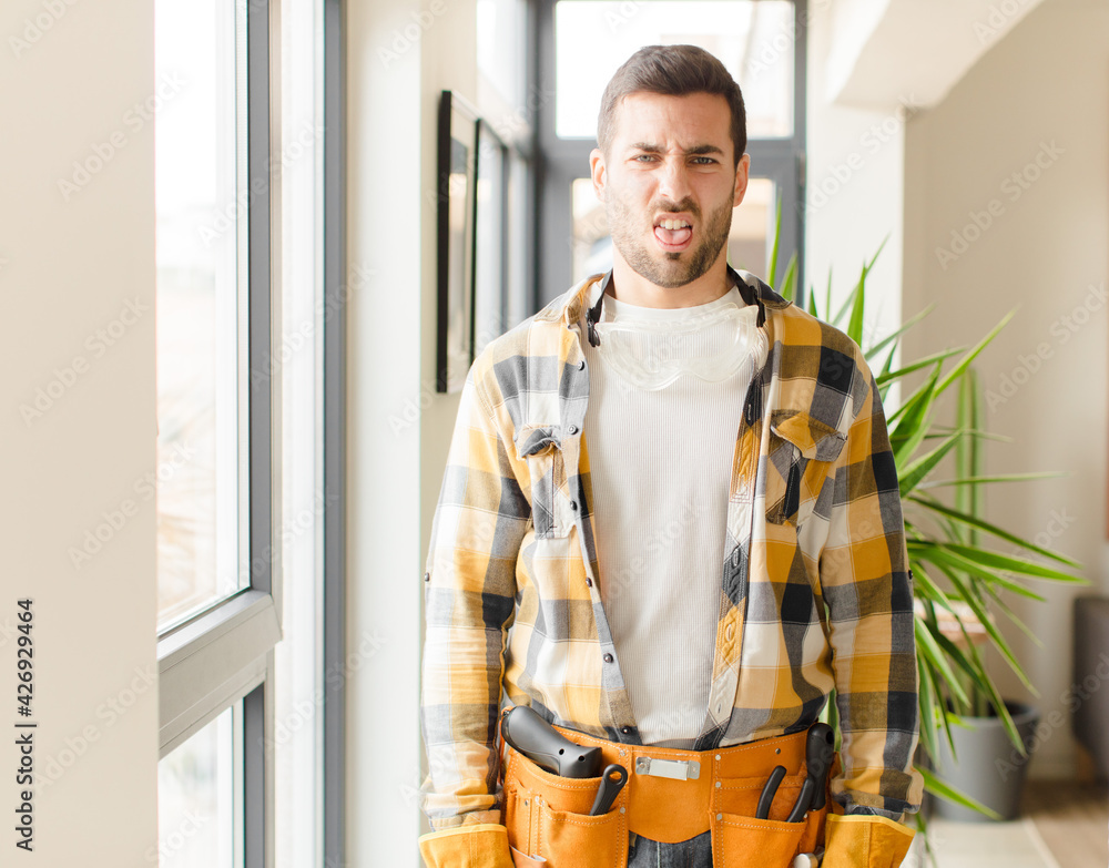 handyman feeling disgusted and irritated, sticking tongue out ...