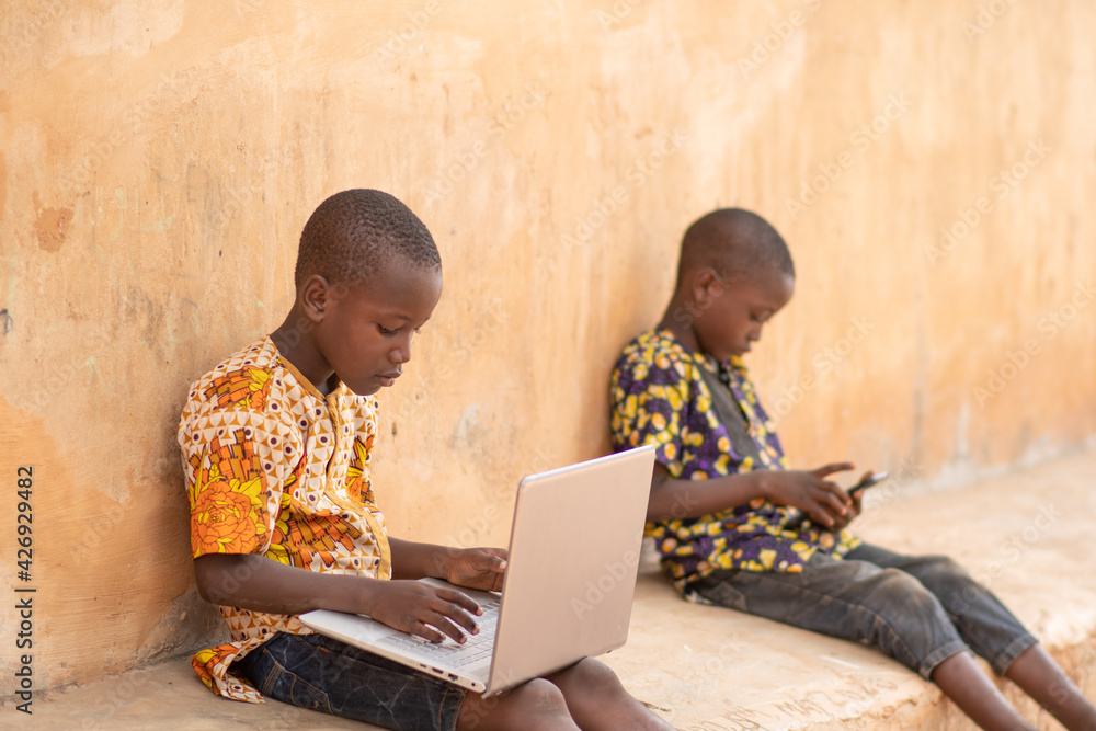 one african kid using a laptop and the other using a mobile phone Stock ...