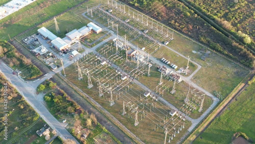 Electrical substation: transformers and grid of pylons, lines and wires ...