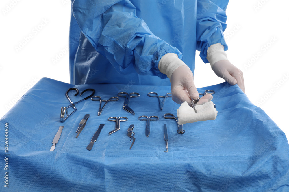 Doctor holding medical forceps with pad near table of different ...