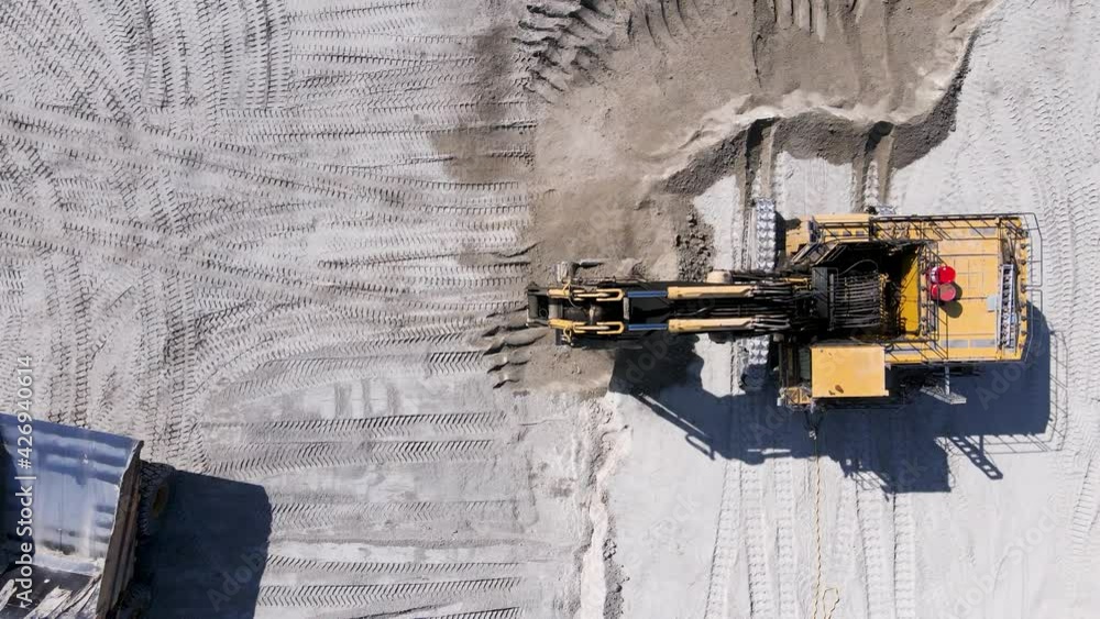 Extraction of coal. View from above. A large excavator loads earth into ...