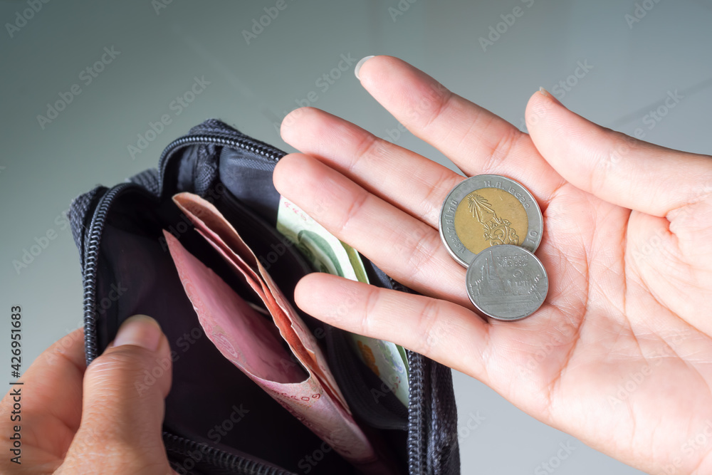 Hand holding coin and wallet on white background. she Little money left ...