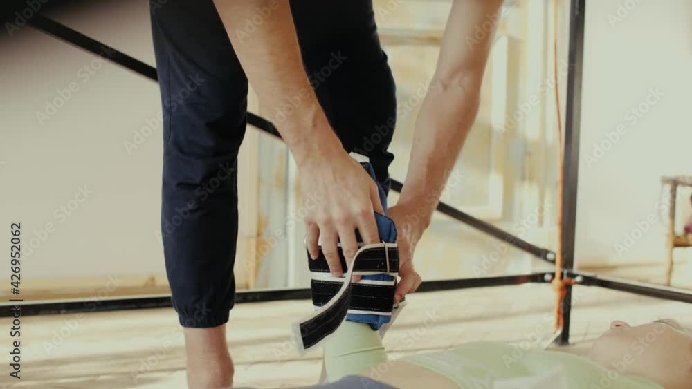 Trainer putting on sports equipment on a woman's hand after training ...