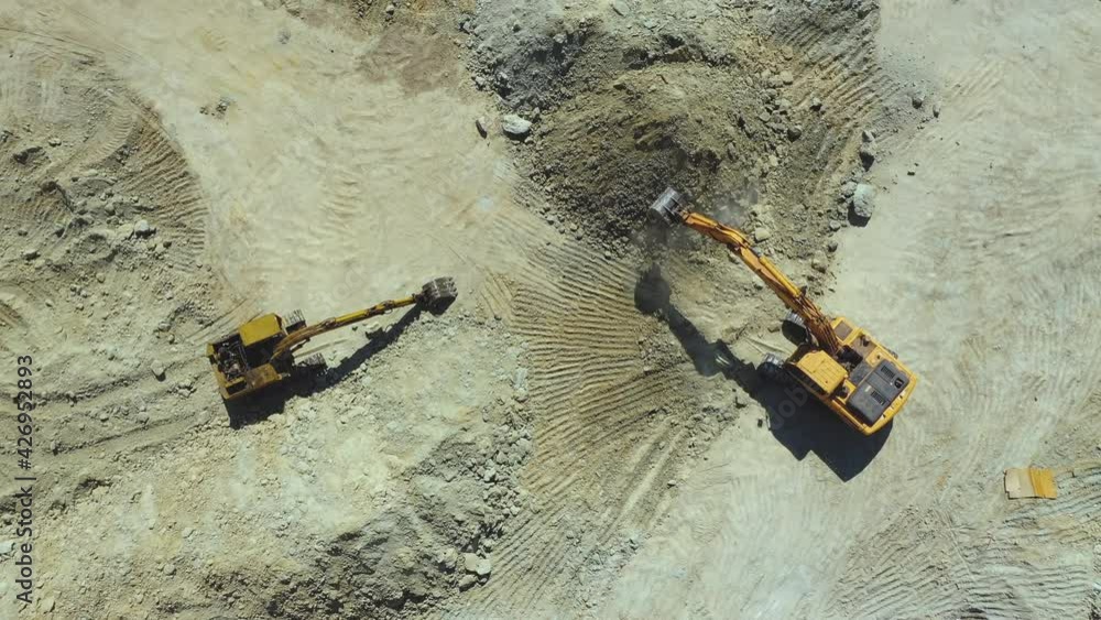 Aerial view footage (top view), orange excavator working in quarries ...