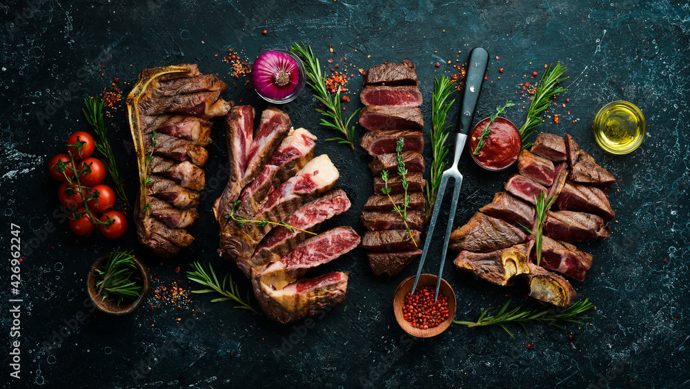 Steak menu. Sliced steaks on a black stone background: t-bone ...