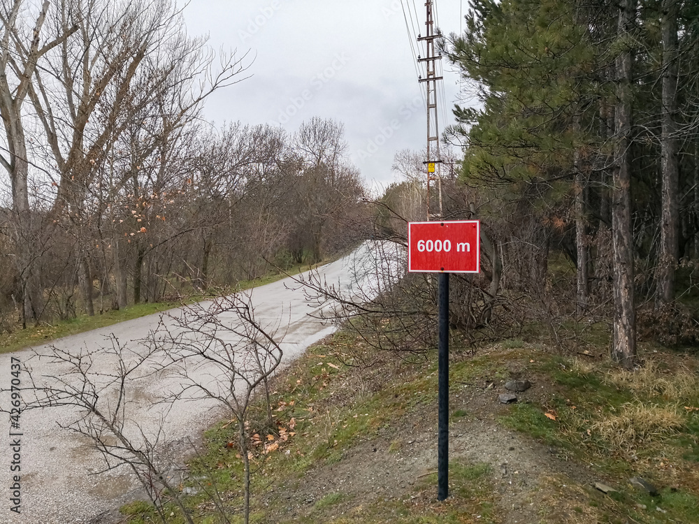 Signboard showing distance for walking in the forest.The red sign says ...