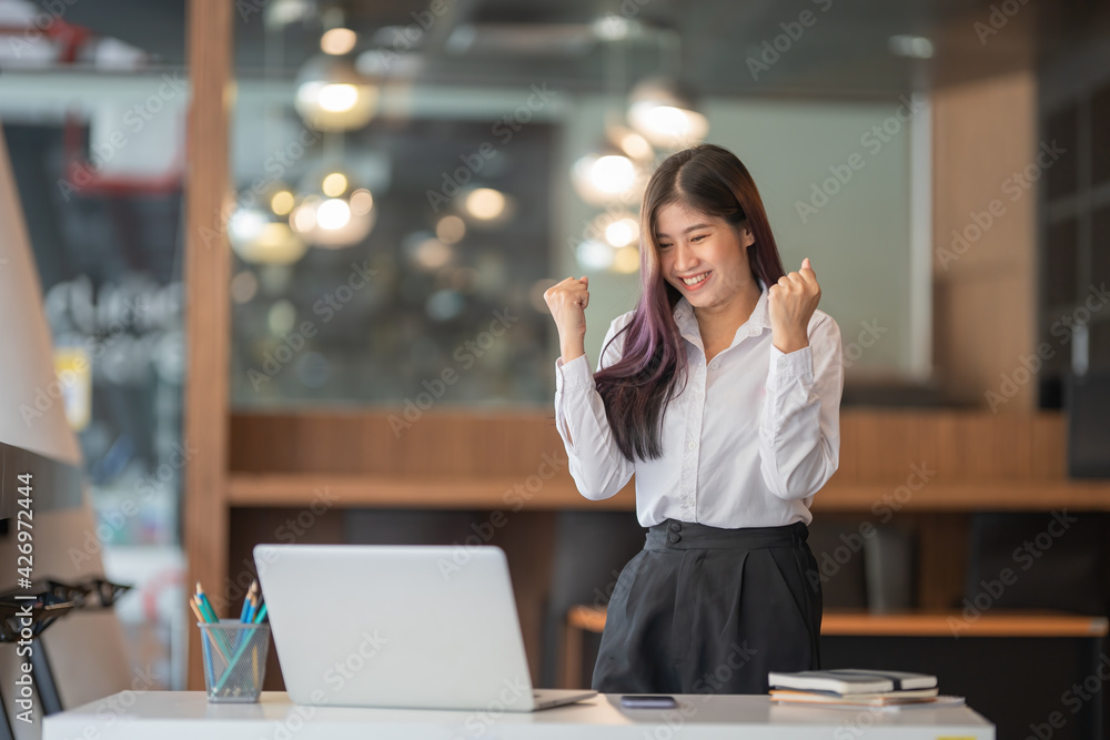 Portrait of female office worker celebrating her accomplishment while ...