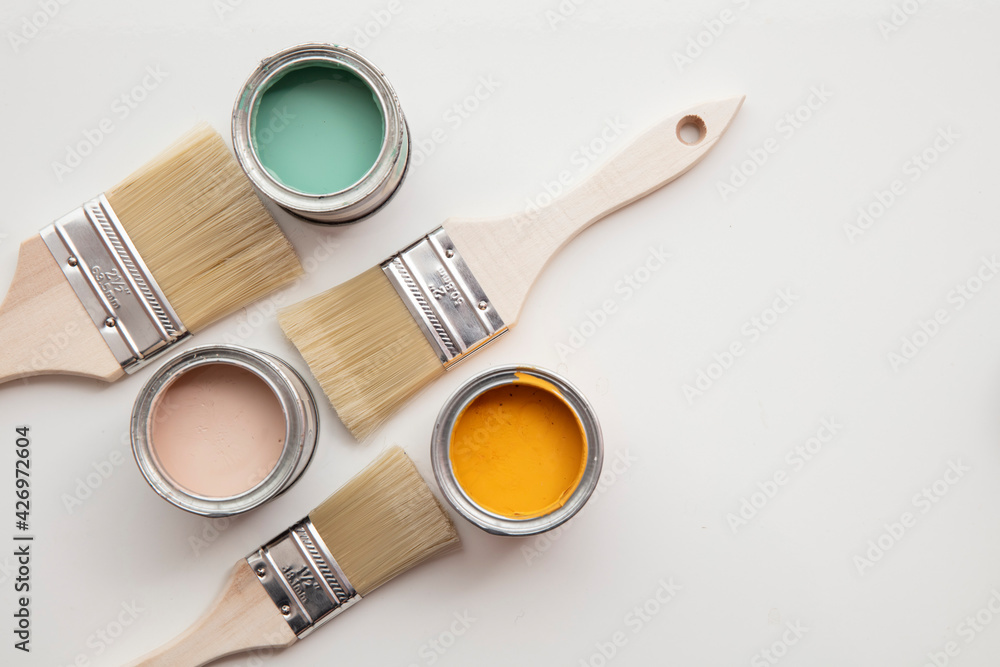 Overhead view of a DIY paint brush with colorful sample paint pots ...
