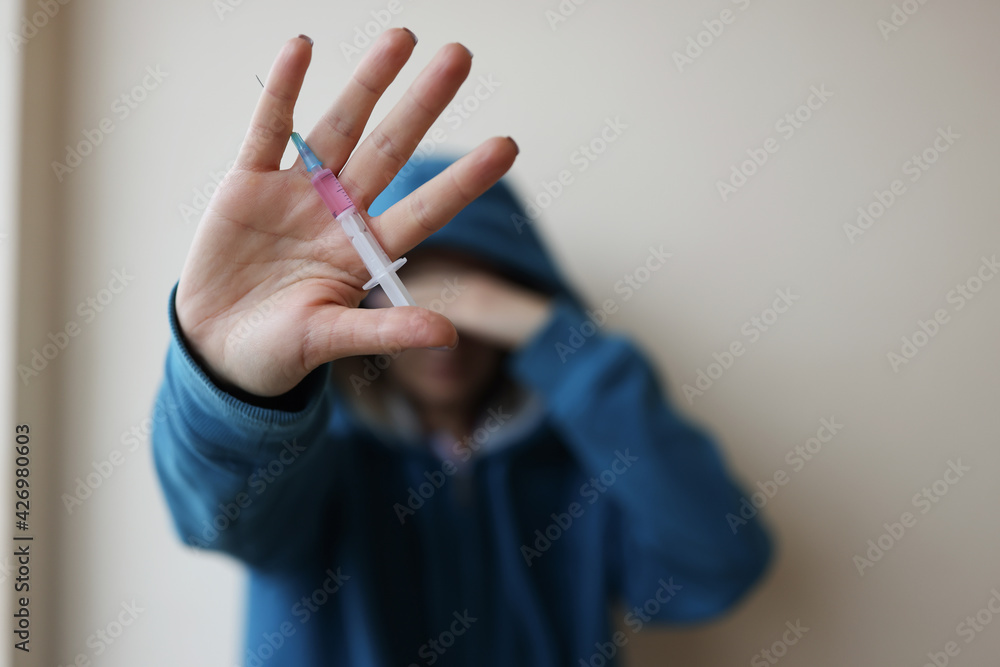Addict is holding syringe with needle in his hand Stock Photo | Adobe Stock