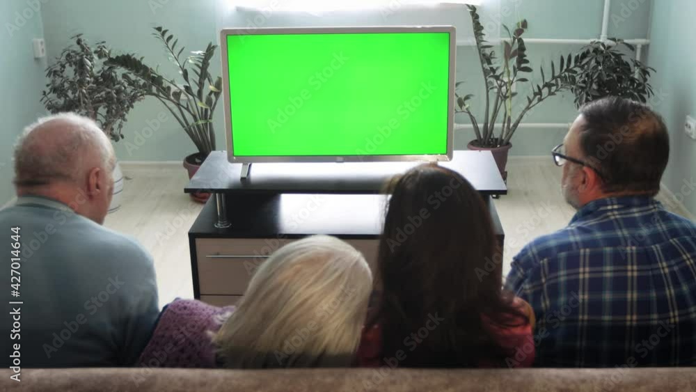 Family watching TV. Green screen. A family of two generations is ...