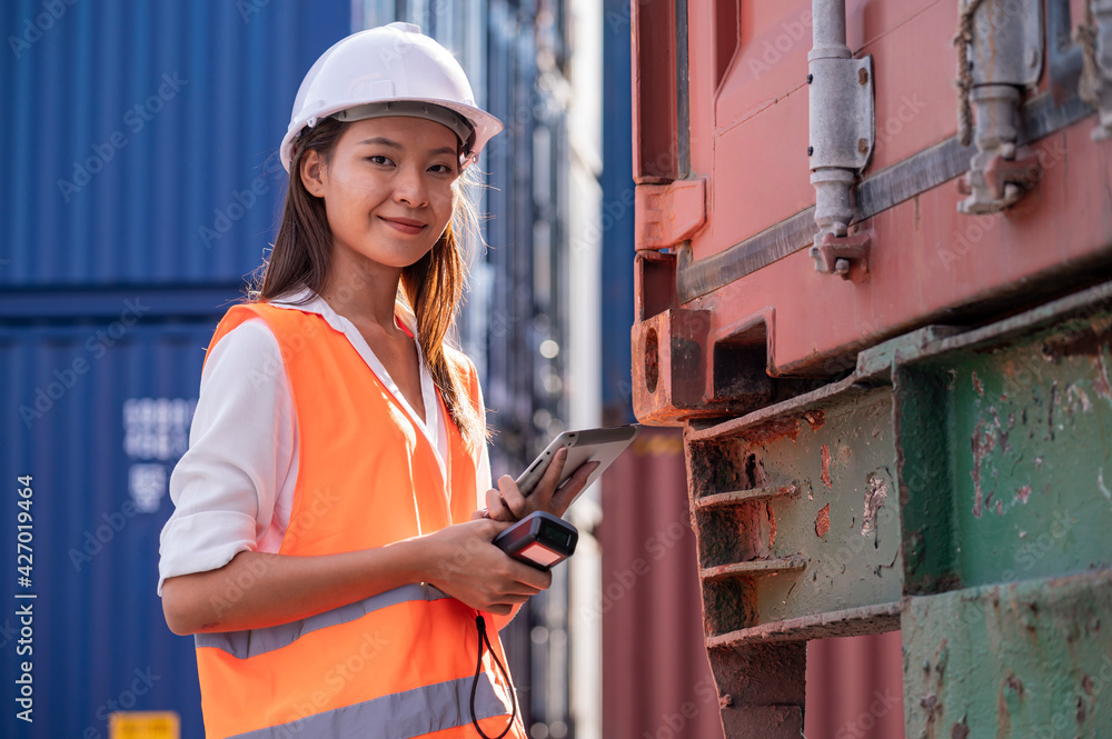 Smile Asian woman logistics worker wear safety helmet and protect suite ...