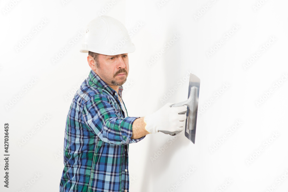Construction worker wearing safety helmet plastering white wall with ...