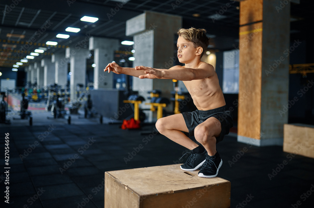 Athletic boy doing balance exercise in gym Stock Photo | Adobe Stock