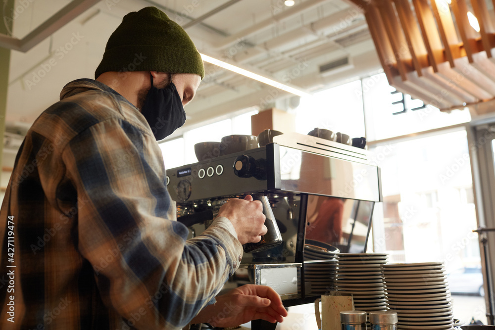 Side view at male barista using coffee machine while making fresh ...