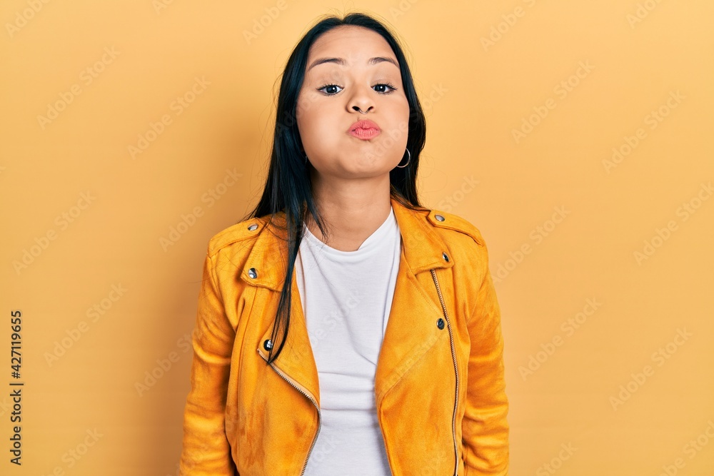 Beautiful hispanic woman with nose piercing wearing yellow leather ...