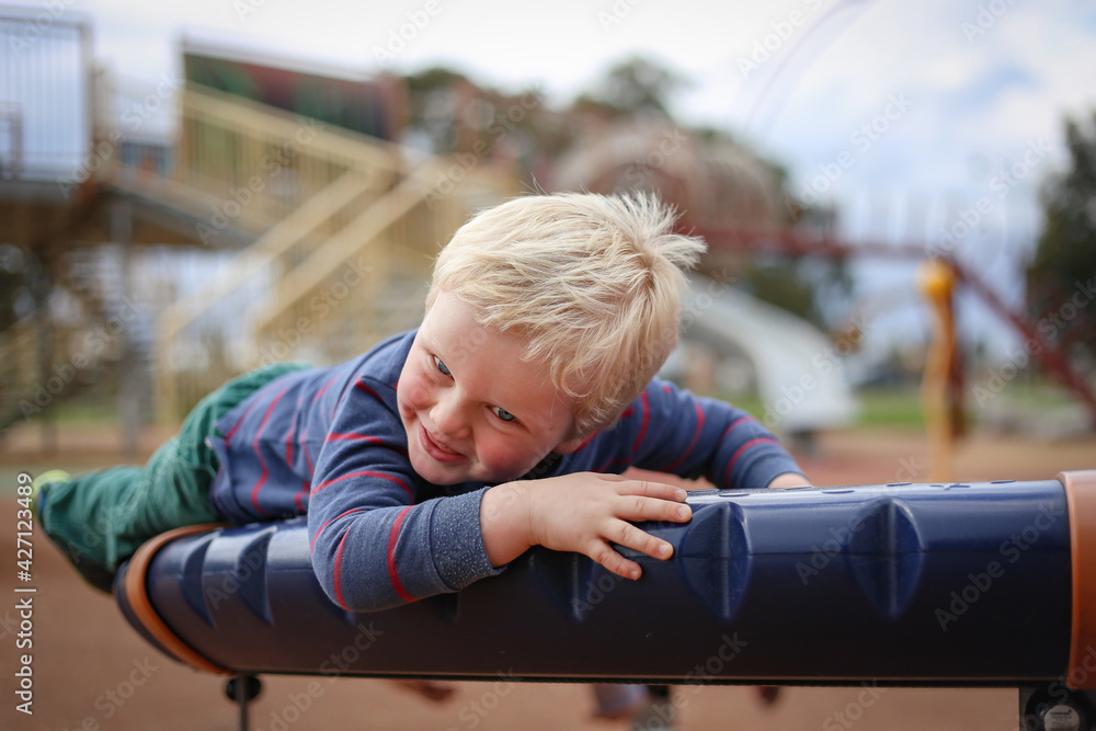 Little boy playing on playground equipment with big smile Stock Photo ...