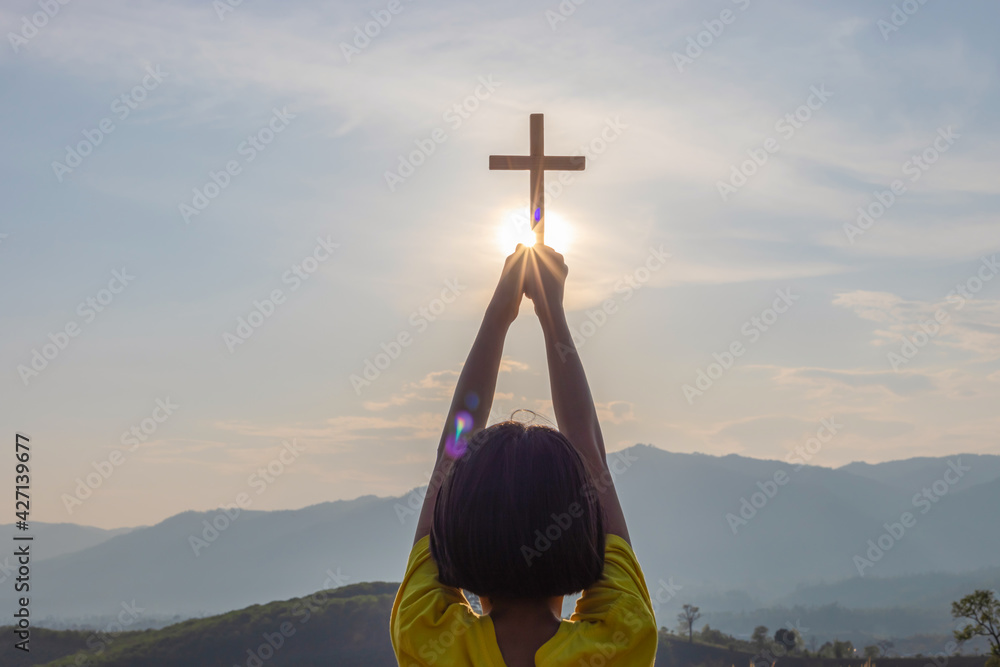 Child praying to the GOD while holding a crucifix of Jesus Christ at ...