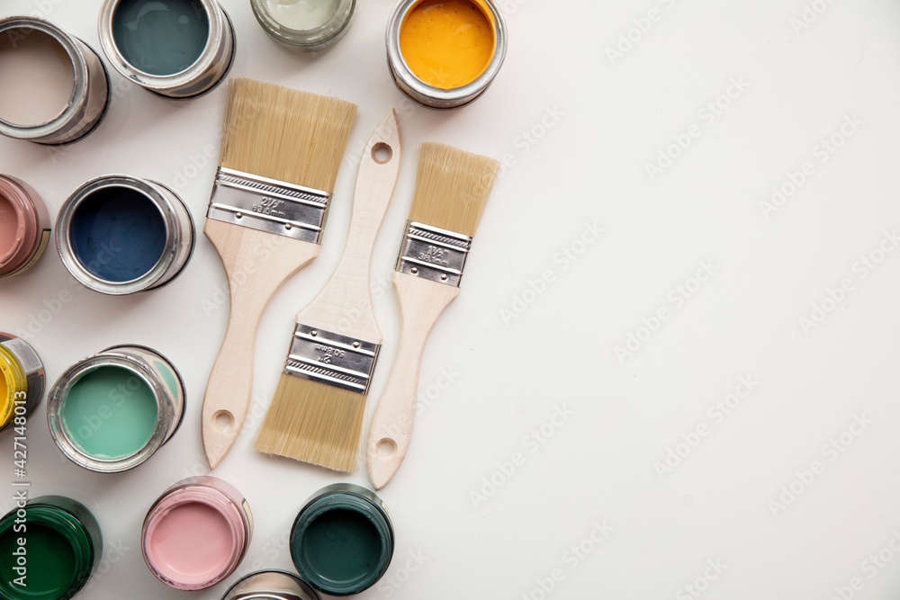 Overhead view of a DIY paint brush with colorful sample paint pots ...