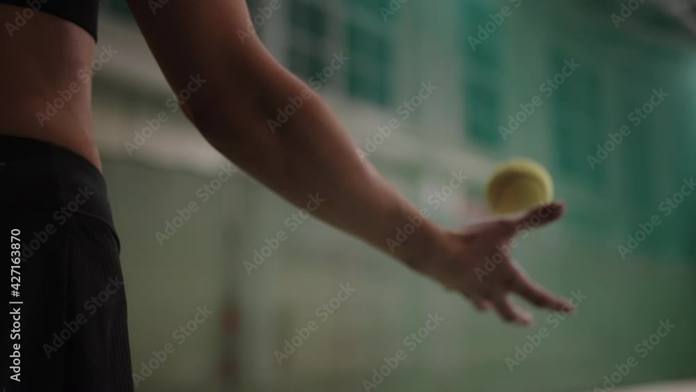 training of pro female tennis player, closeup of hand throwing ball up ...