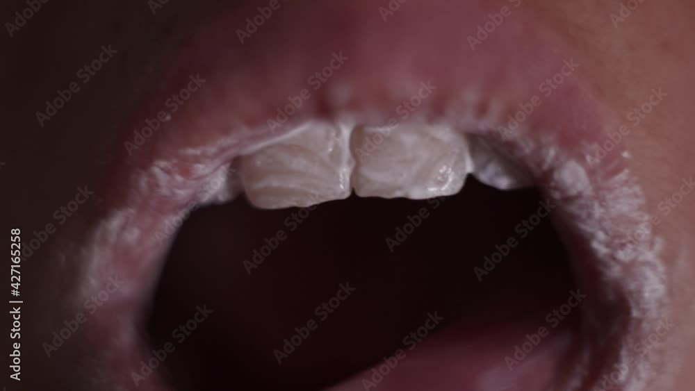 Extreme close-up view of person brushing teeth with pink toothbrush and ...