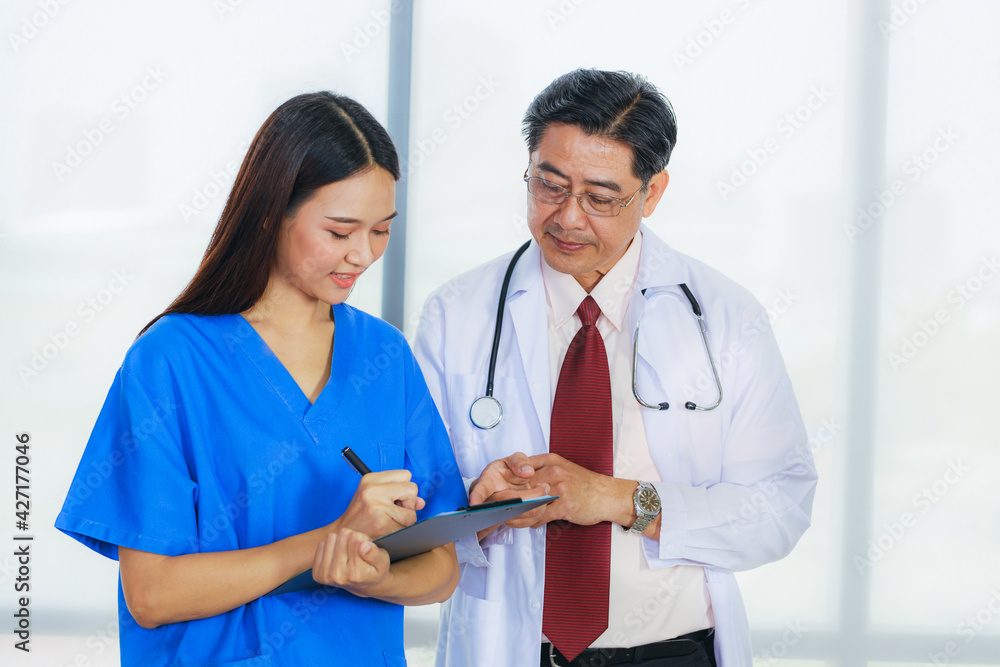 Senior Asian male doctor wearing eye glasses with young female doctor ...