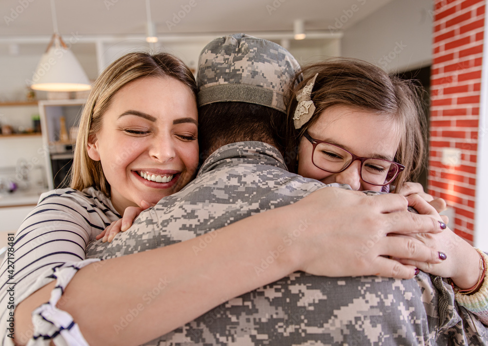 Soldier hugging with his family at home. Stock Photo | Adobe Stock