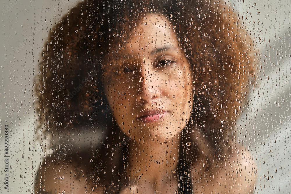 Sensual portrait of young woman taking a shower. Defocused female looks ...