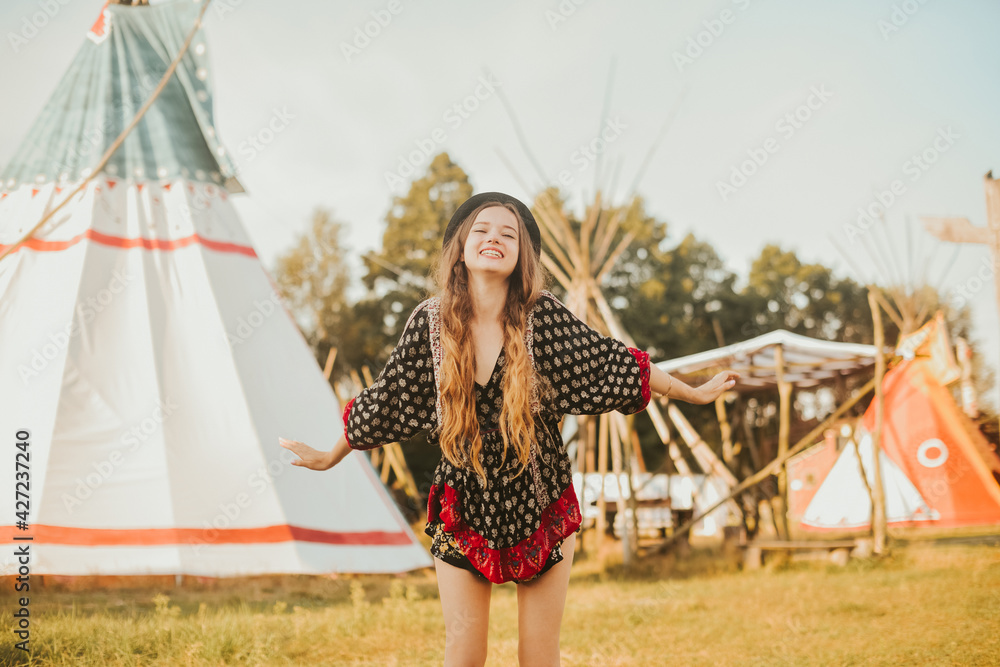 Young beautiful girl smiling on background teepee, tipi- native indian ...