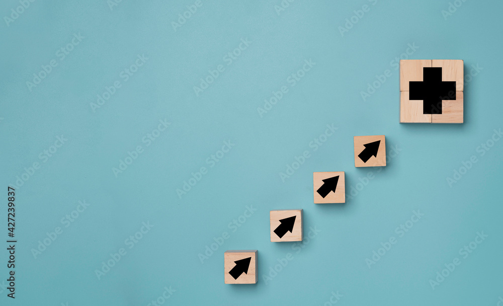 Plus sign and increasing arrow print screen on wooden cube block on ...