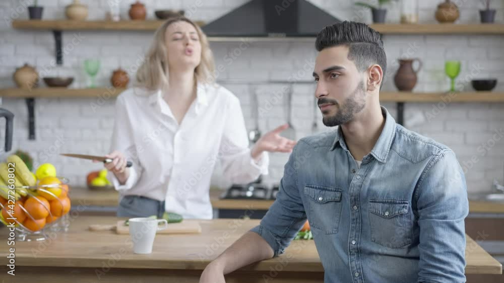 Sad young Middle Eastern man listening to Caucasian woman complaining ...