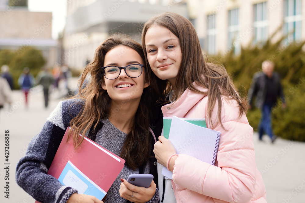 Cheerful attractive girls students going home after the classess in the ...