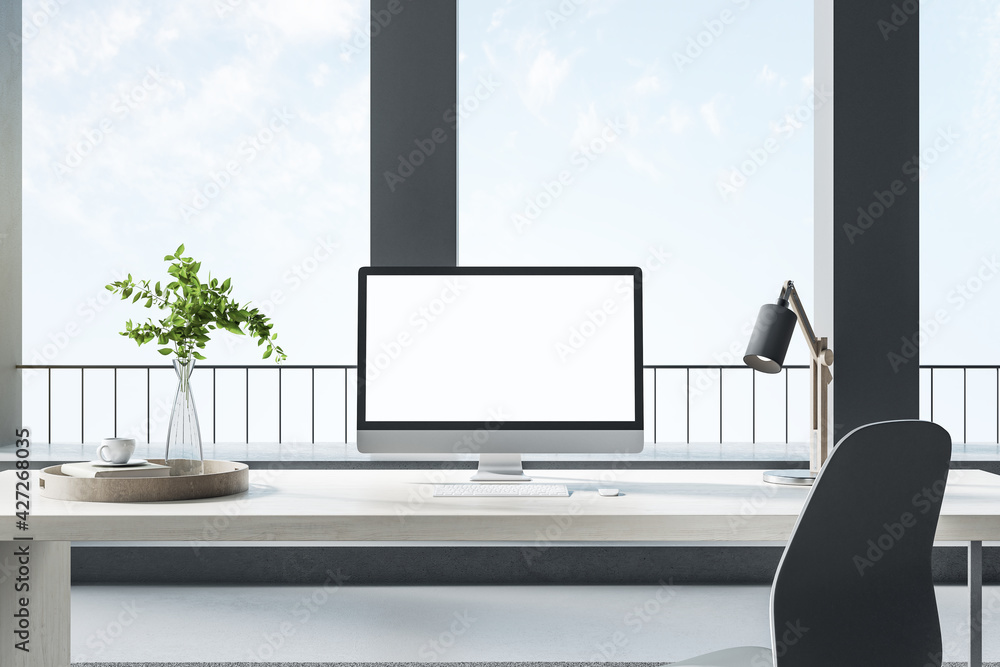 Pc standing on a desk in a bright room with black columns and big ...