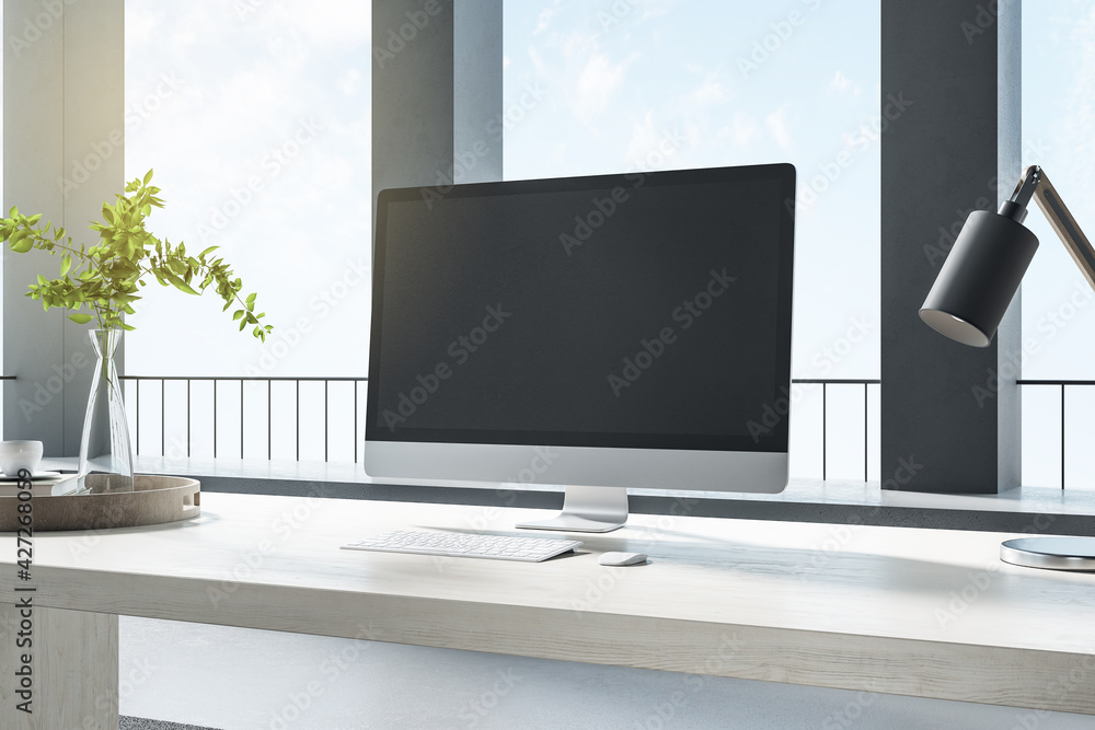 Pc standing on a desk in a bright room with black columns and big ...