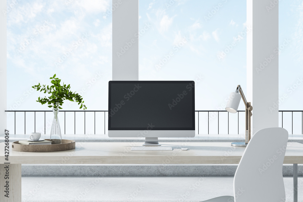 Pc standing on a desk in a bright room with columns and big windows ...