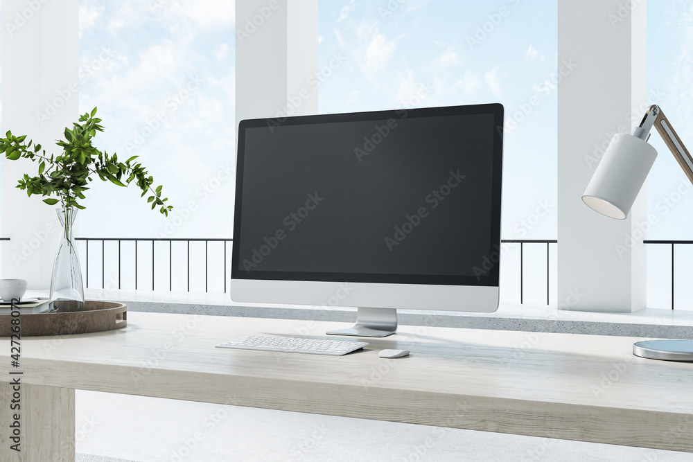 Pc standing on a desk in a bright room with columns and big windows ...